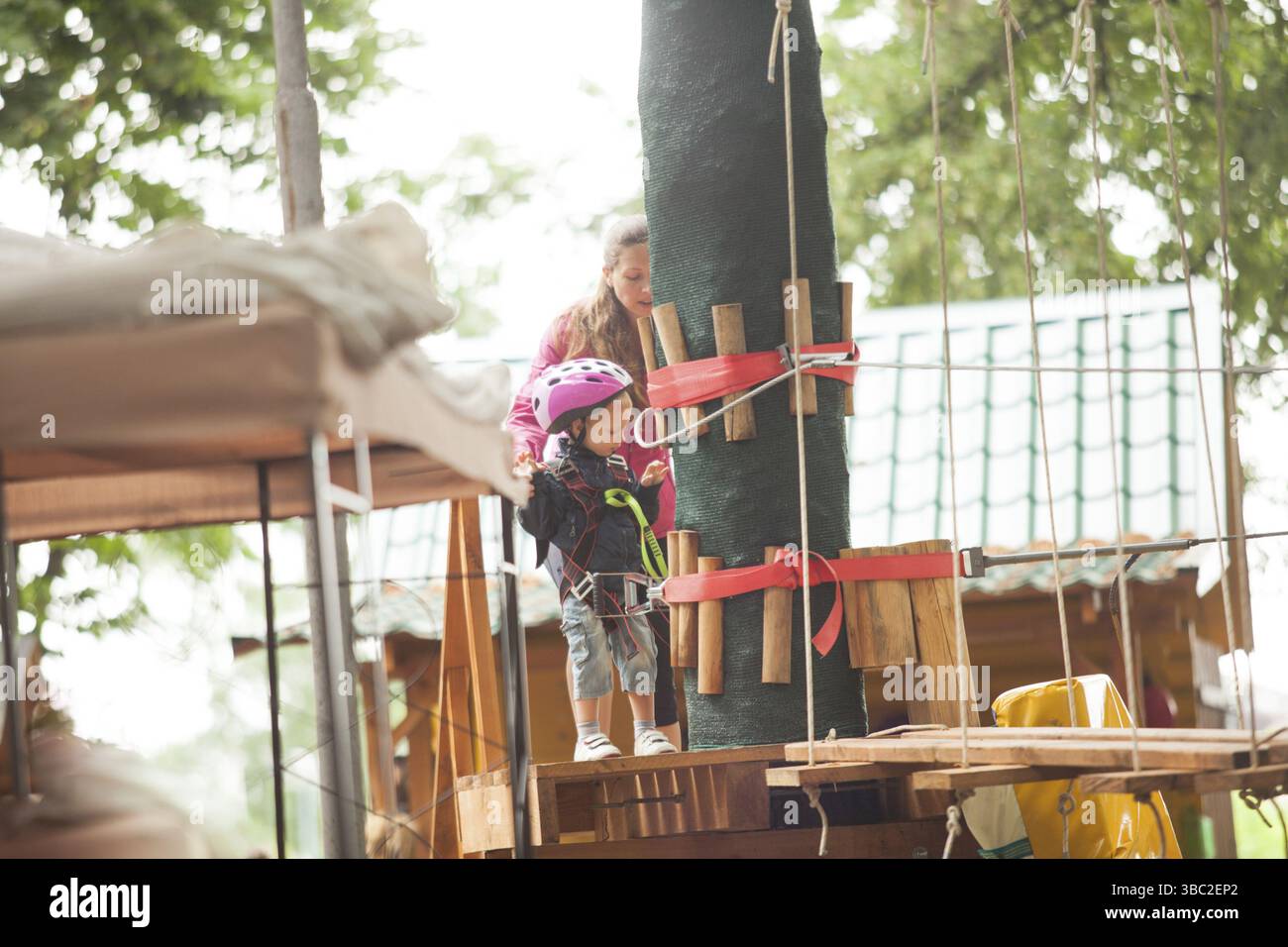 Kids on obstacle course in adventure park in mountain helmet and safety ...