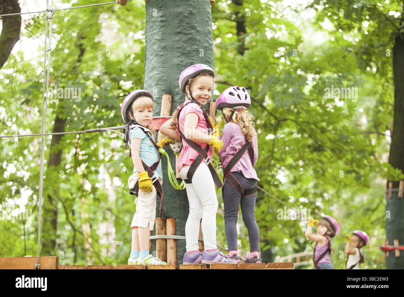 Kids on obstacle course in adventure park in mountain helmet and safety ...