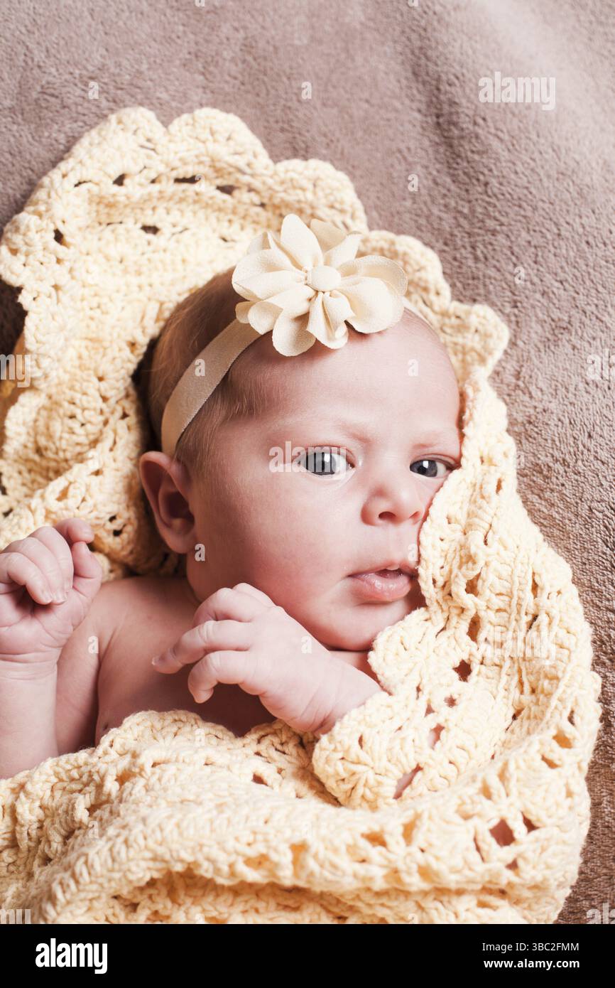 Newborn baby girl in the crochet yellow blanket Stock Photo - Alamy