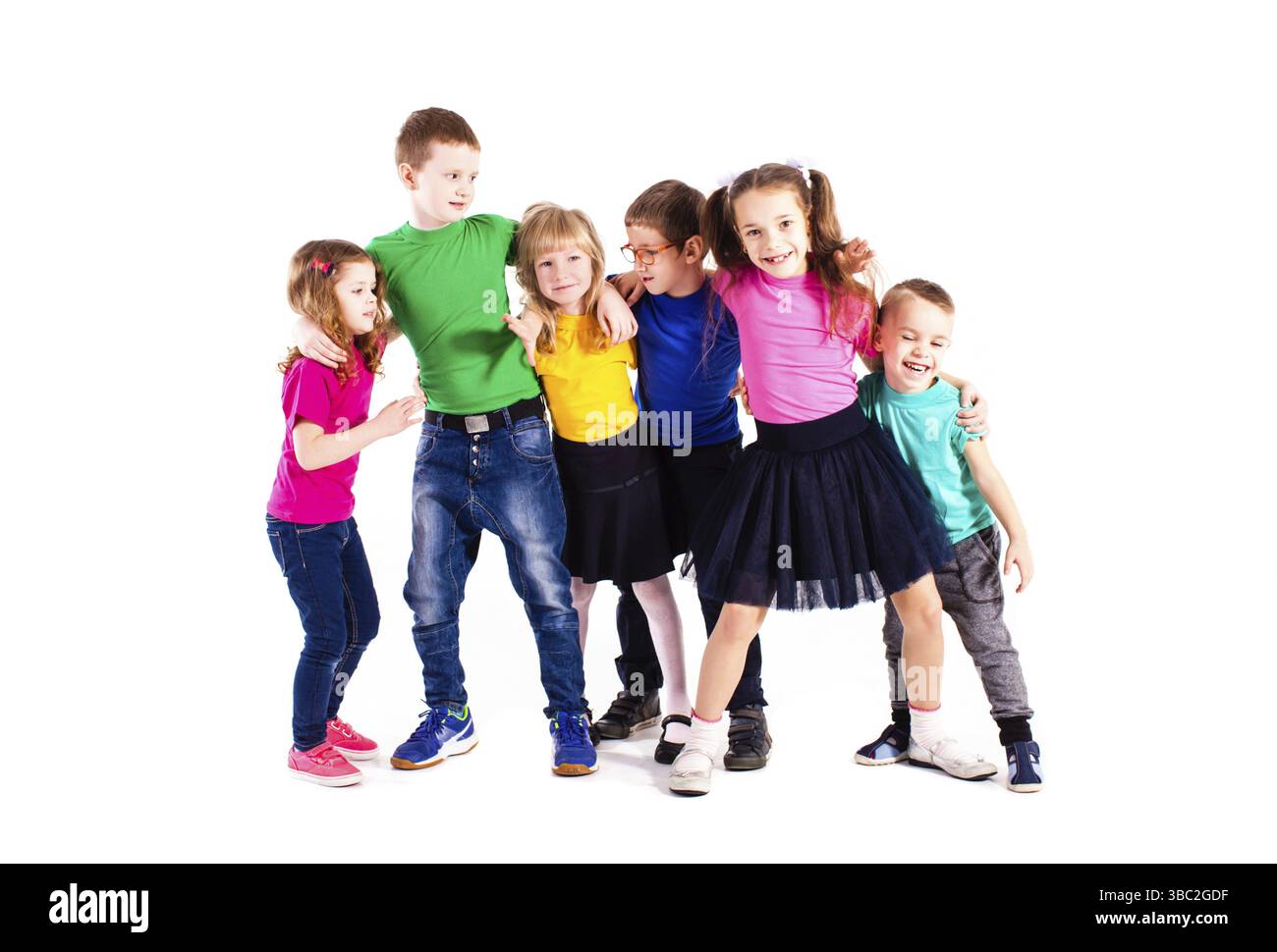 The happy kids are standing together embracing each other in colorful ...