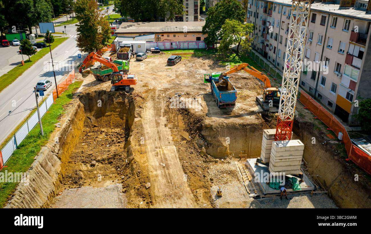 Above view on two big excavators as they digging, excavating foundation for new residential ...