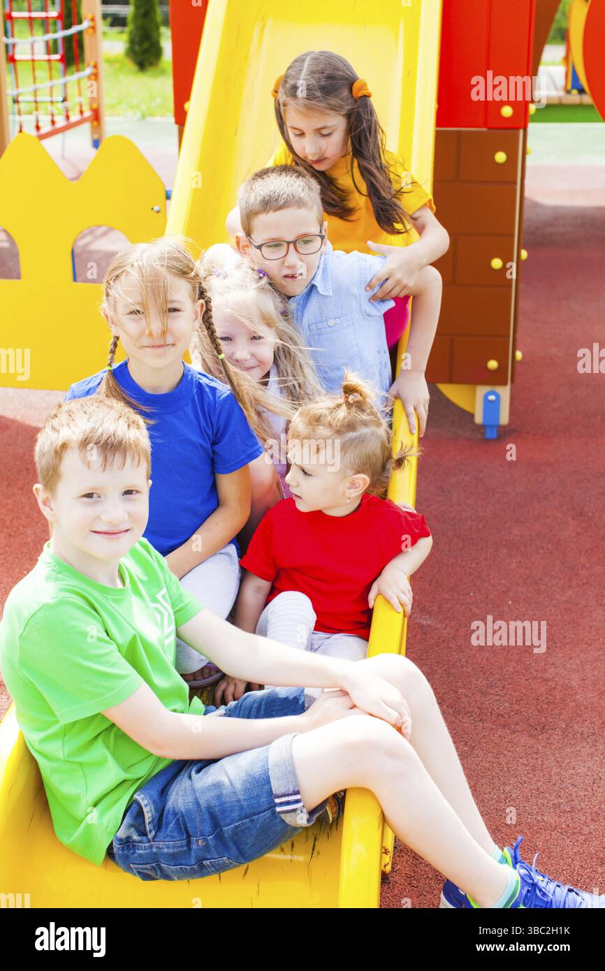 Happy kids playing outdoors. Children at the playground on slide Stock ...