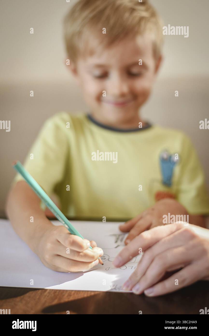 Six years old boy boy learns to write Stock Photo - Alamy