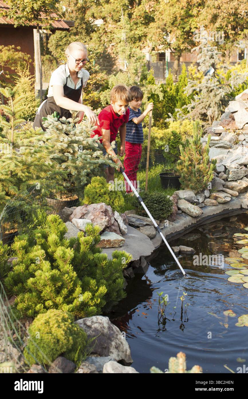 Woman worker shows the boy a pond, pupils on the excursion. Natural ...