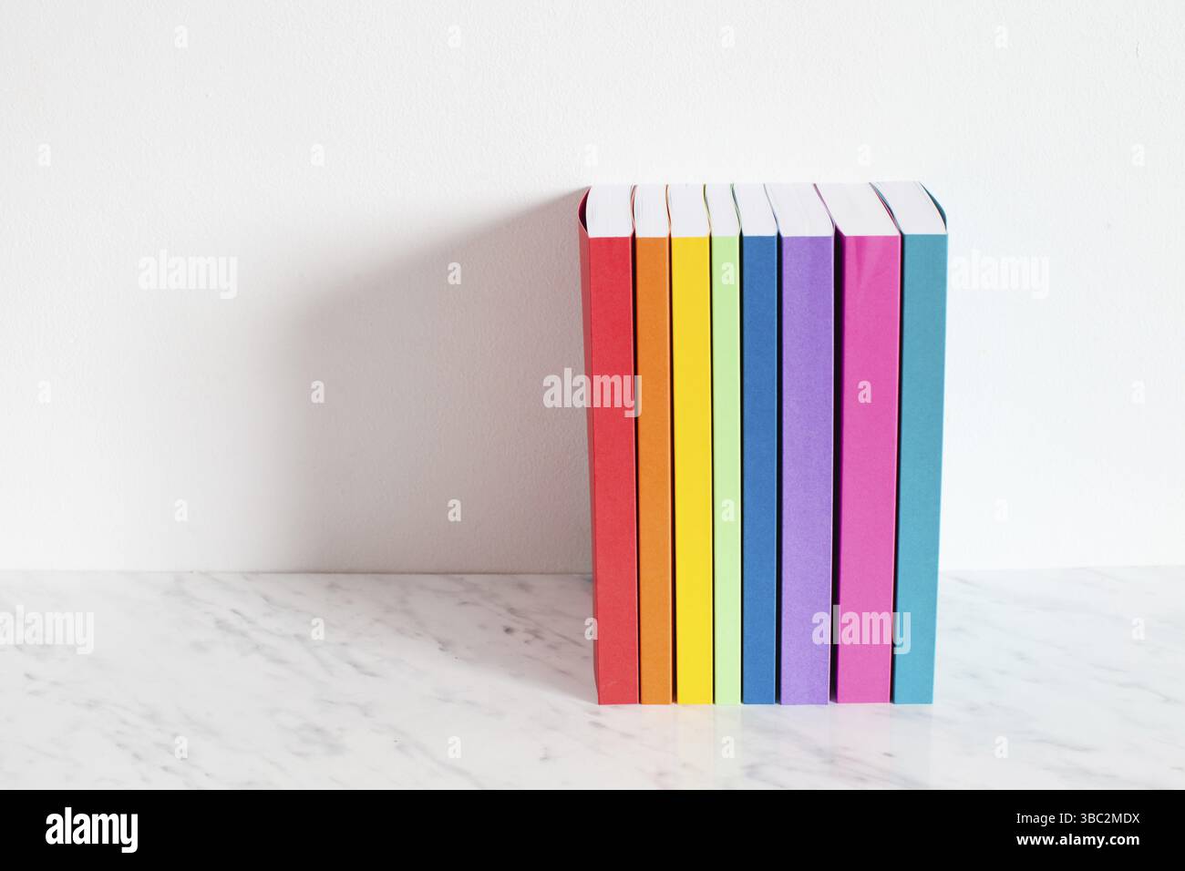 Colorful books are outlined in the colors of the rainbow. Stacked of ...