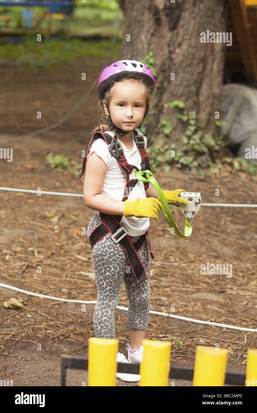 Kids on obstacle course in adventure park in mountain helmet and safety ...