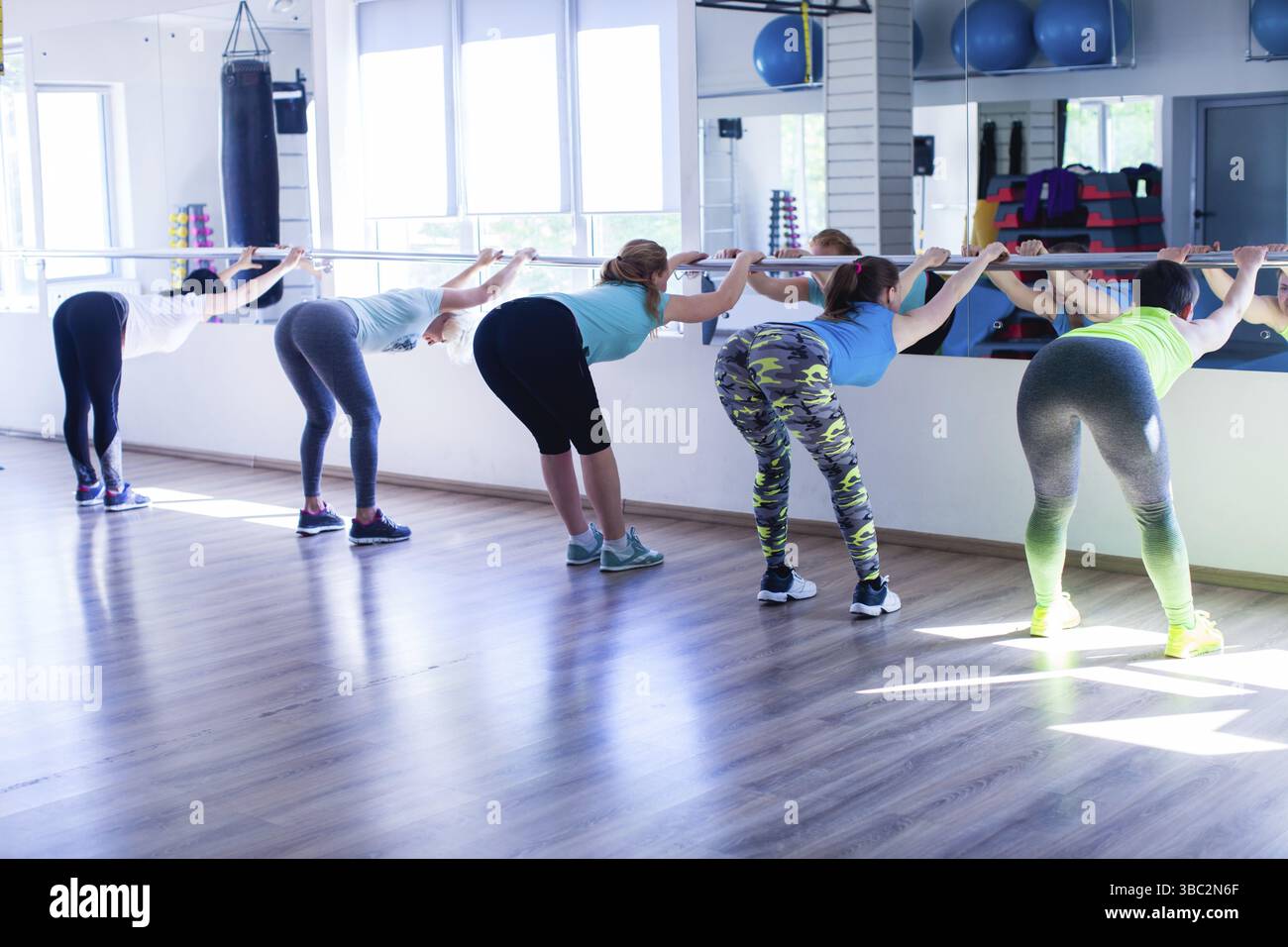 Women doing stretching using the metal railing in the gym Stock Photo ...