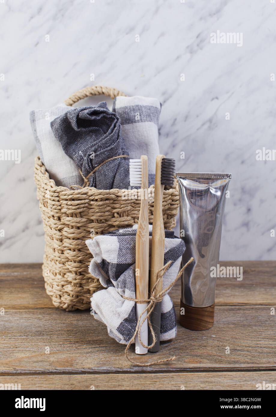 Smal straw basket filled with black and white towels. Two bamboo ...