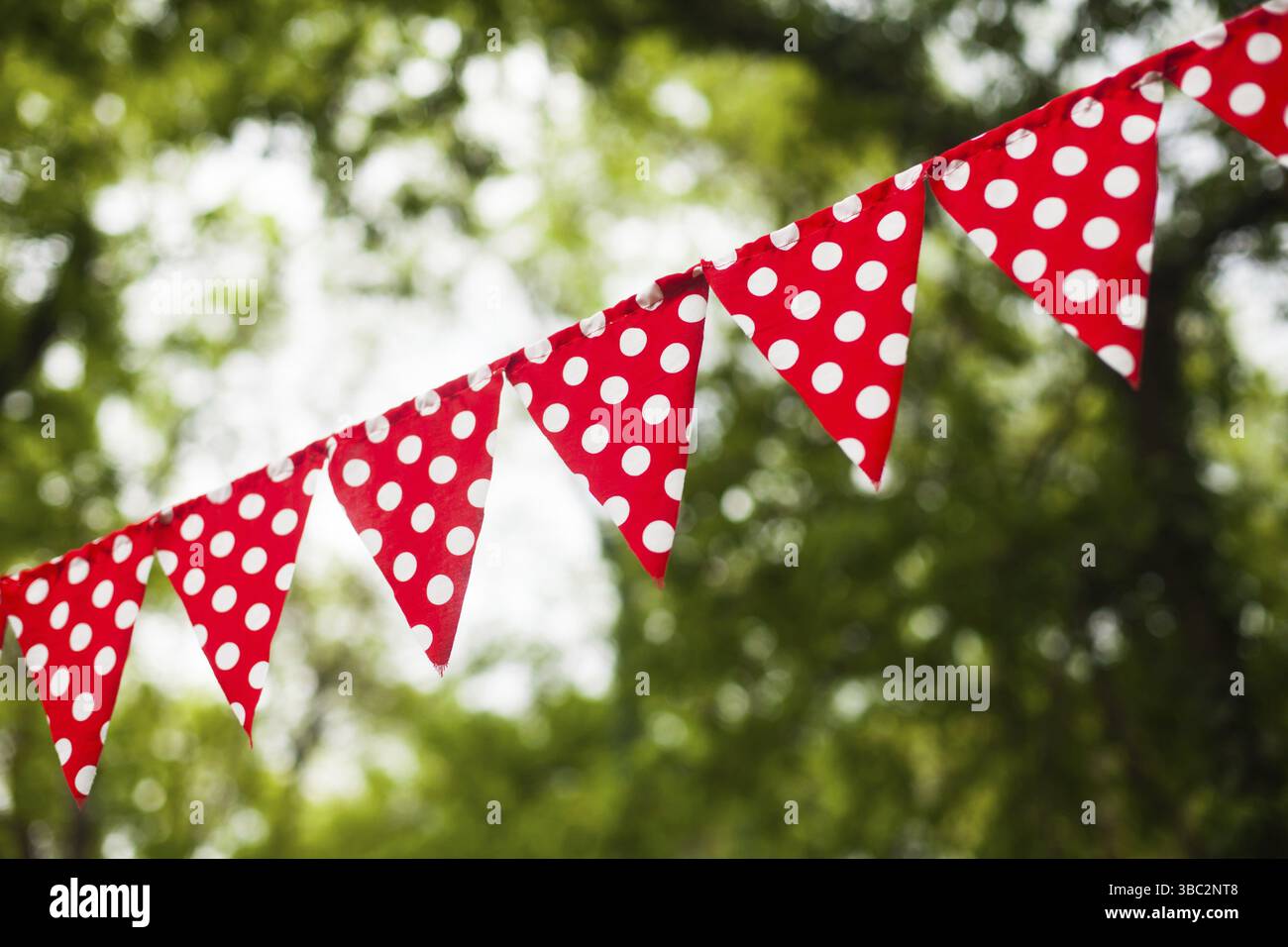 Red triangular flags with white dots on the nature background Stock ...