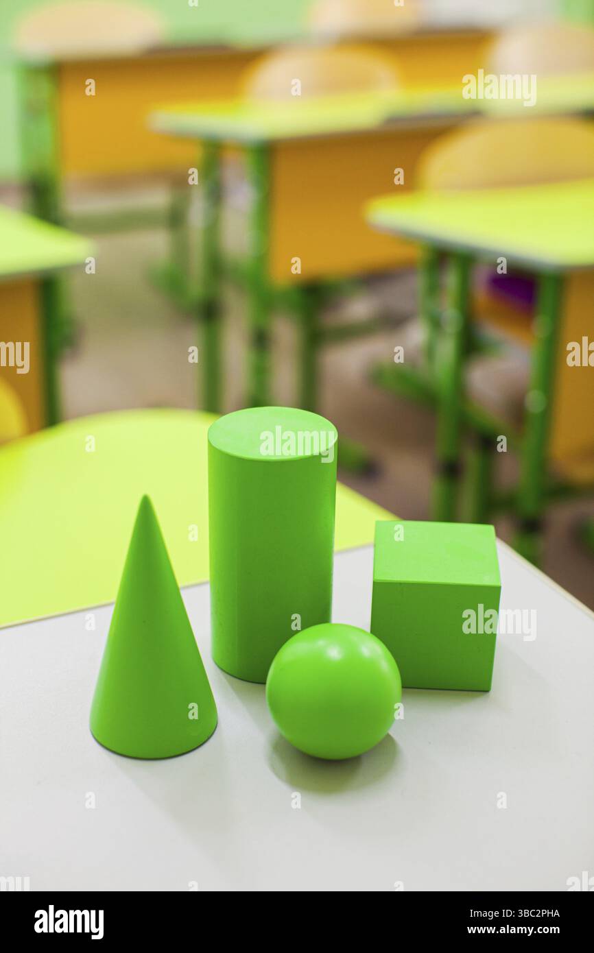 Close up various geometric figures on white surface. Classroom with ...