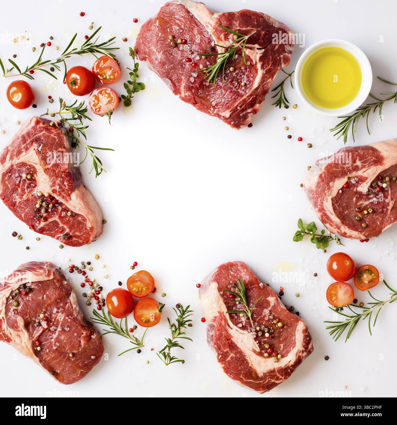 Top view on pieces of raw steaks that are laid out on a white ...