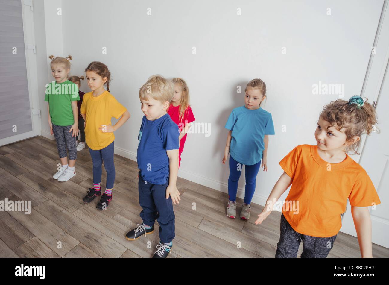 Group of active kindergarten children performing yoga exercises while ...