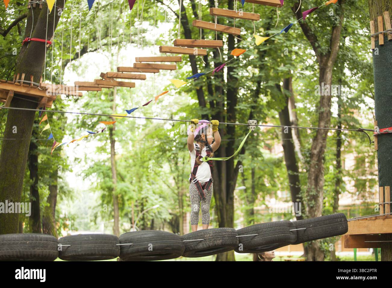 Kids on obstacle course in adventure park in mountain helmet and safety ...