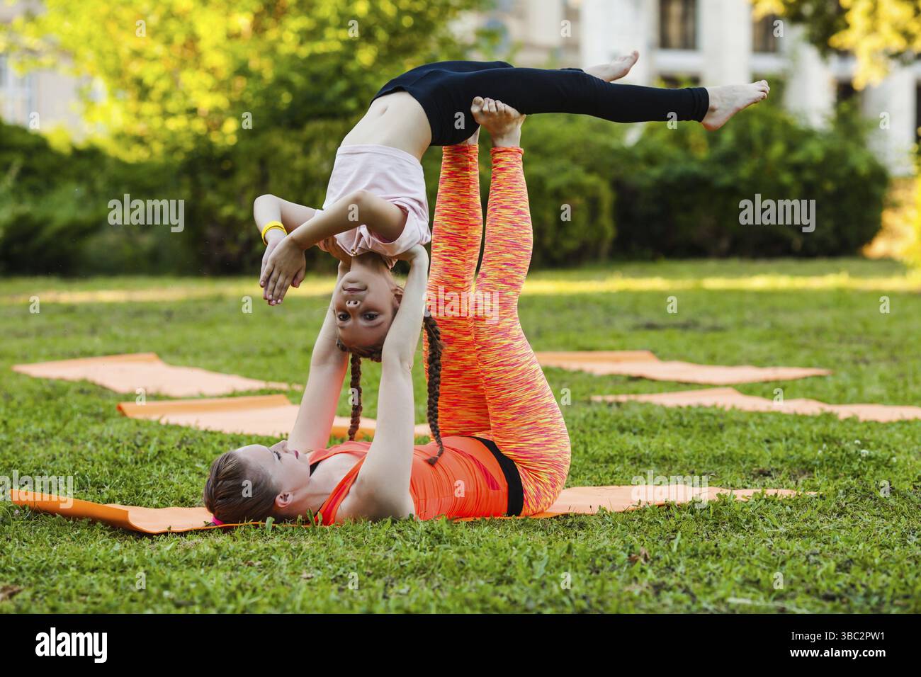 The young mom with her daughter performs an amazing acrobatic figure in ...