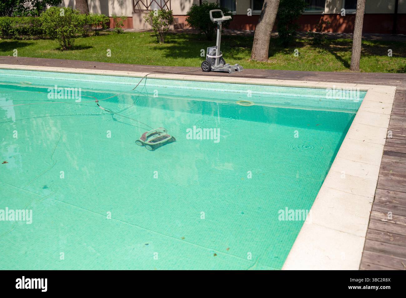A swimming pool with a wooden deck around it, in a hotel garden, and ...