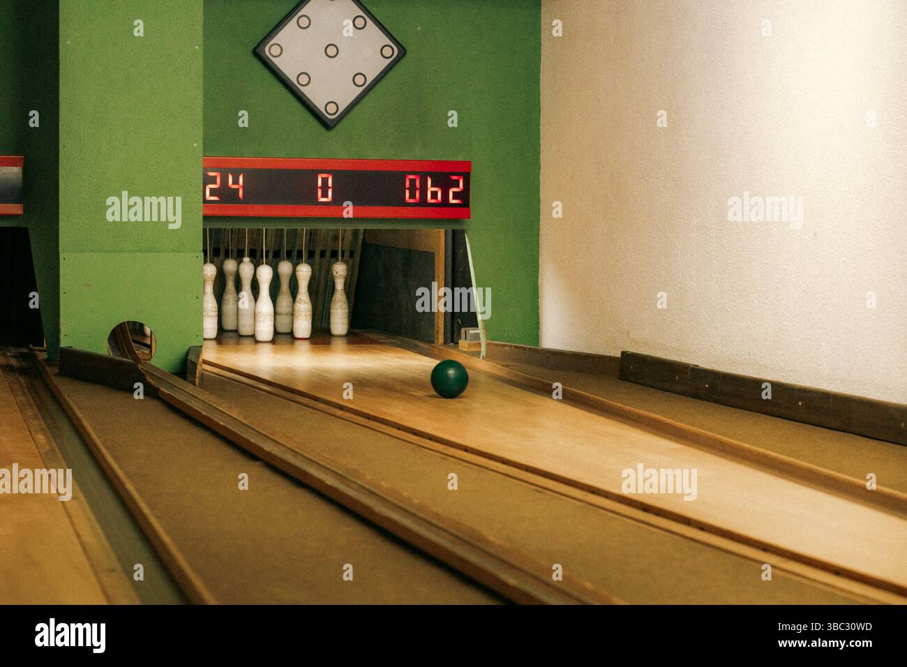 Classic bowling alley with a wooden lane, green bowling ball, and ...