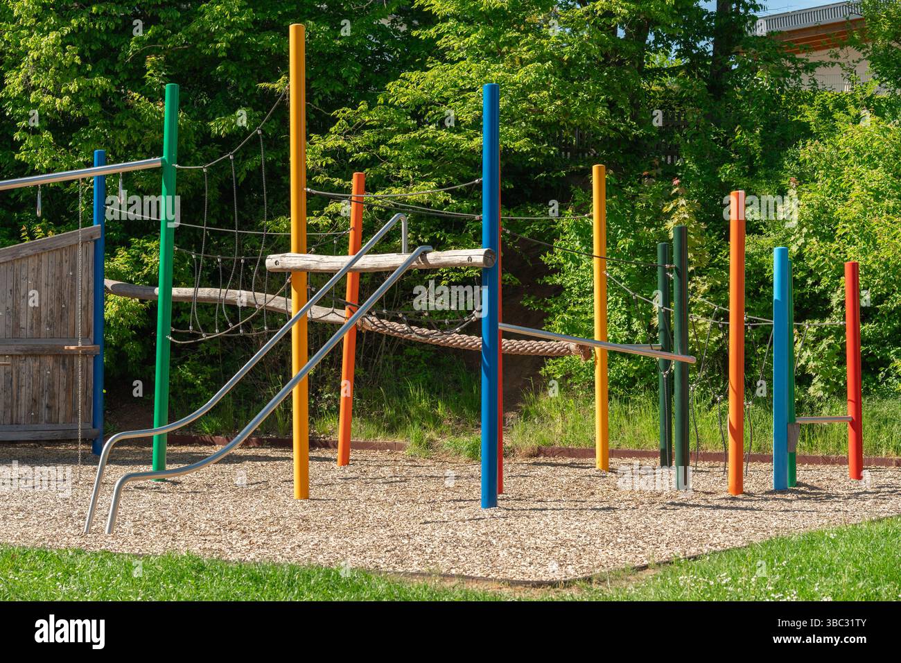 Brightly colored playground equipment featuring a slide, climbing ropes ...