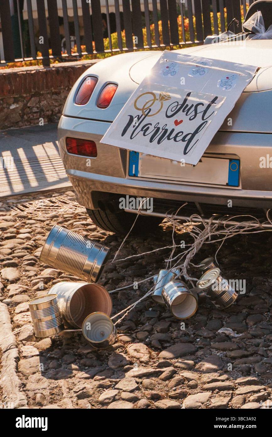 Wedding car with just married sing and cans attached to the back of a ...