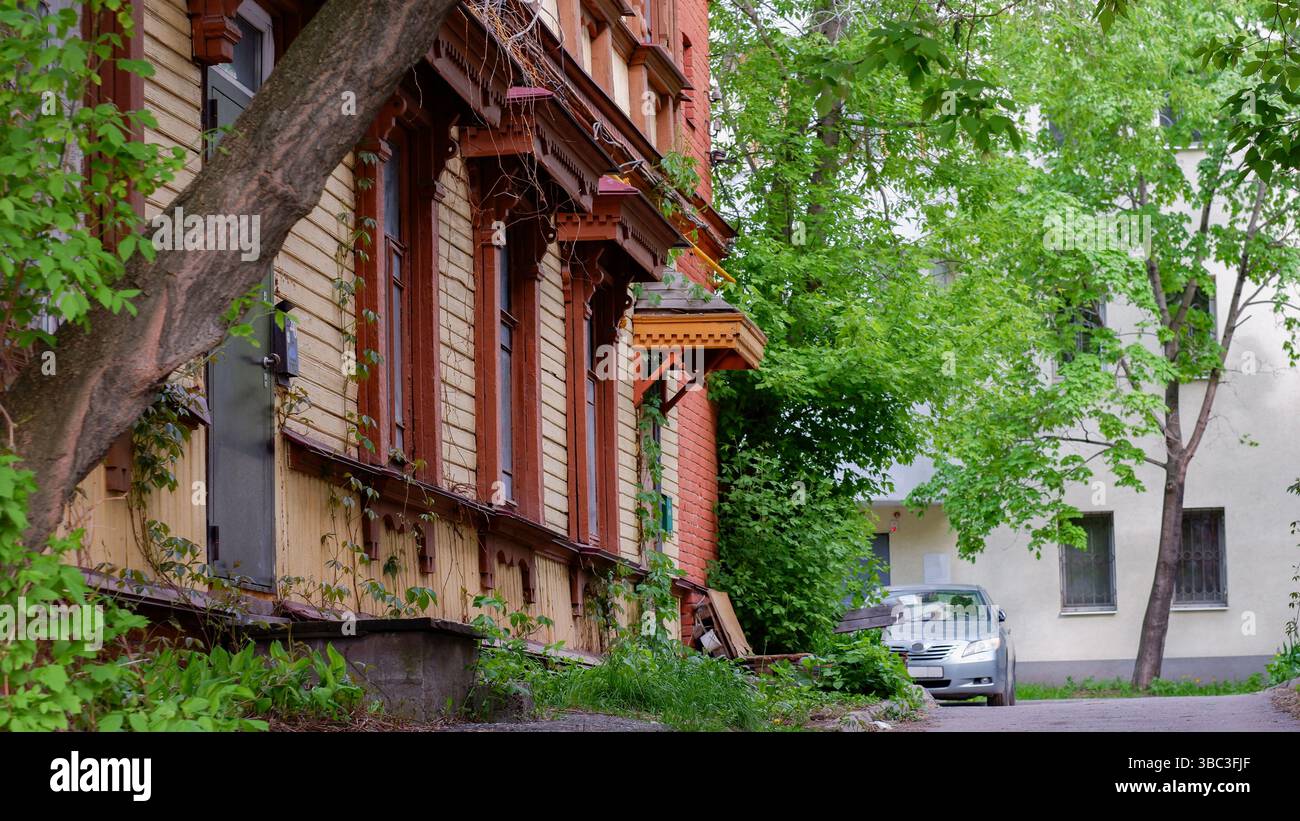 Vintage brown wooden building in a modern city. Traditional Russian ...
