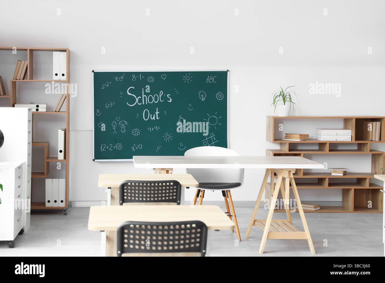Interior of classroom with blackboard, shelf units and desks. End of ...