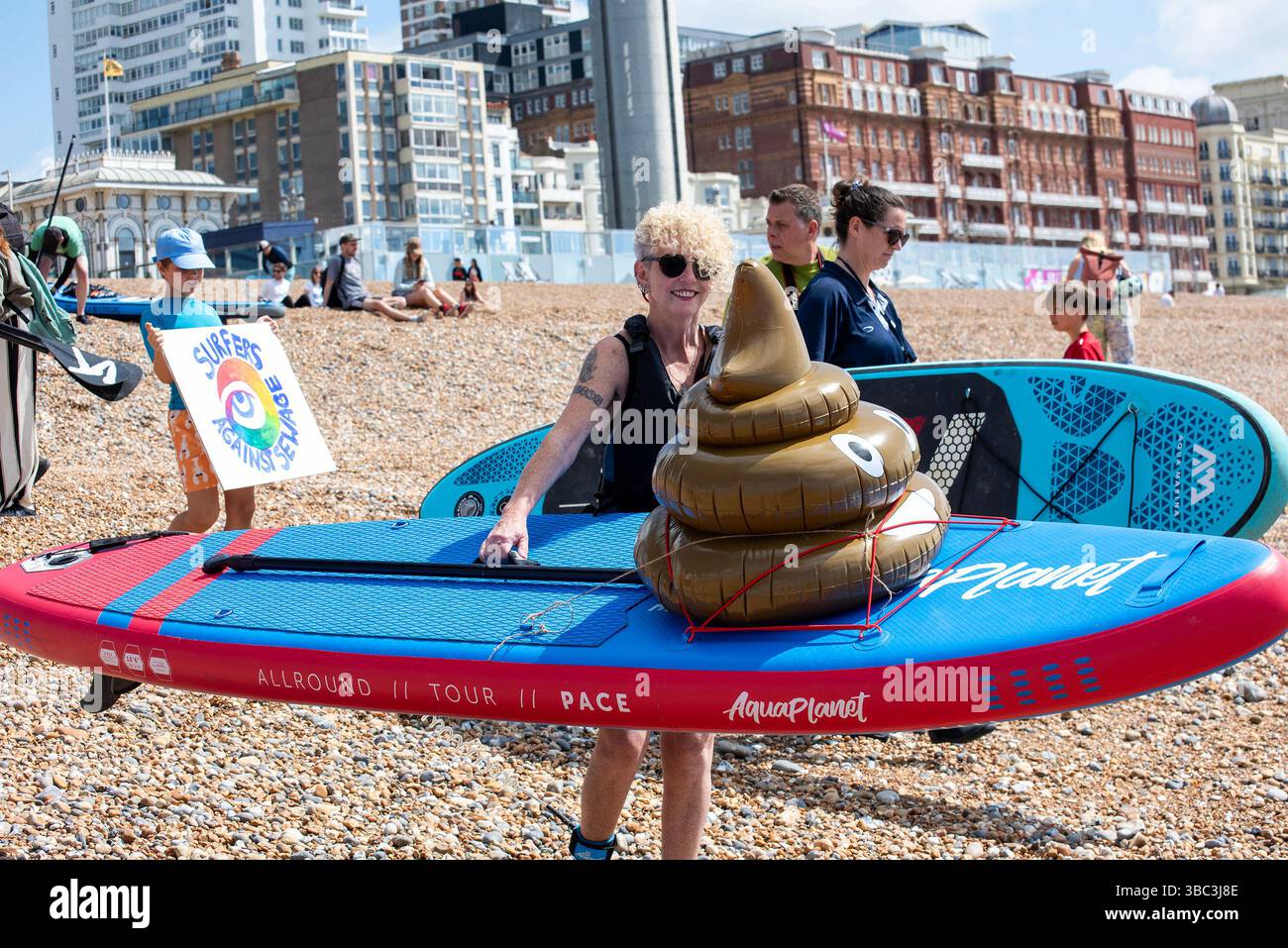 Brighton, UK. 17th May, 2025. A protester carries her paddle board into ...