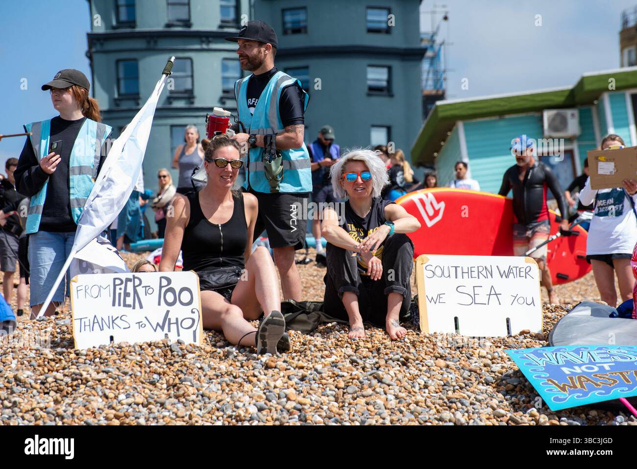 Brighton, UK. 17th May, 2025. Protesters sit next to their placards at ...