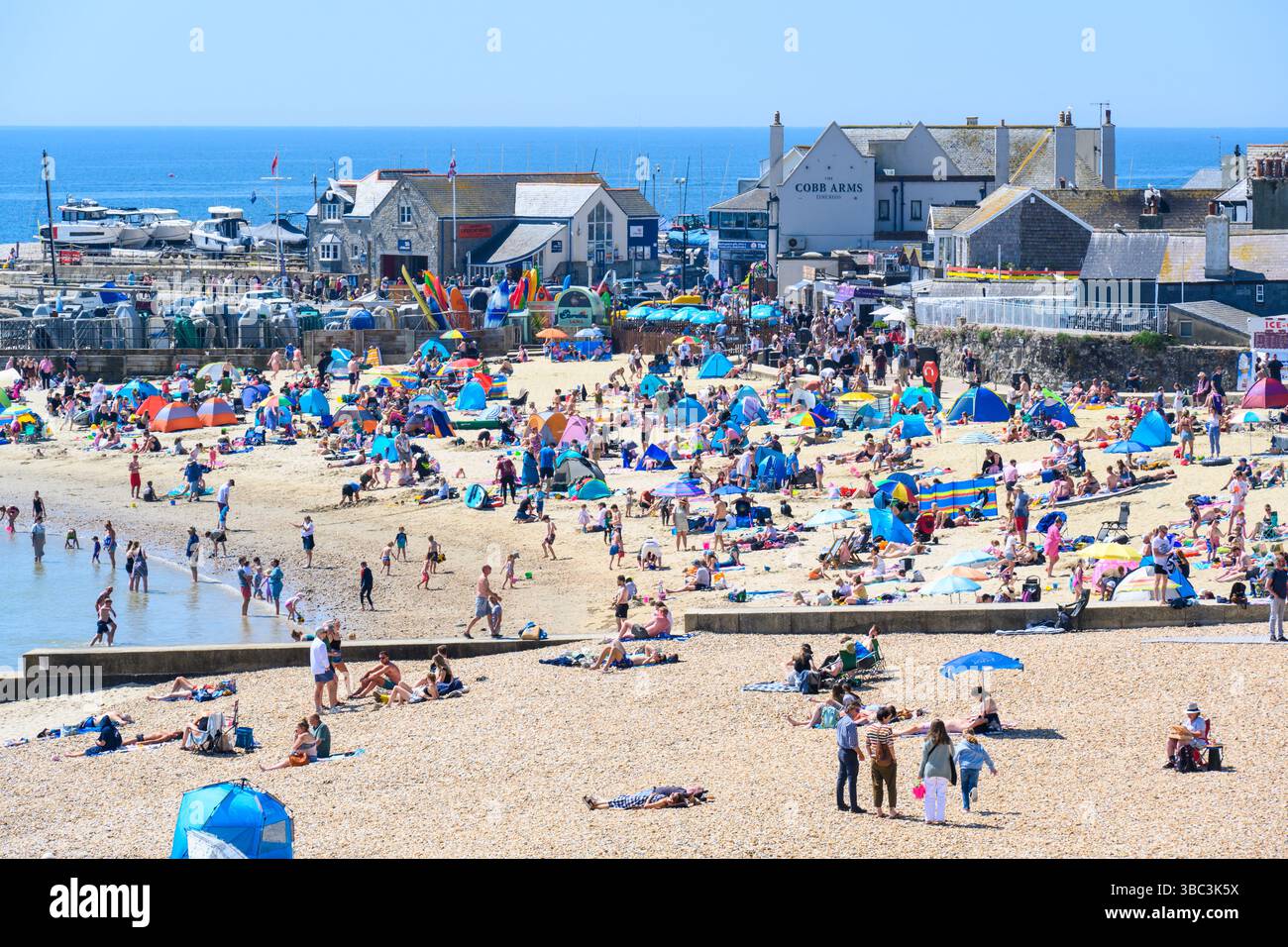 Lyme Regis, Dorset, UK. 18th May, 2025. UK Weather. Sunbathers flock to ...