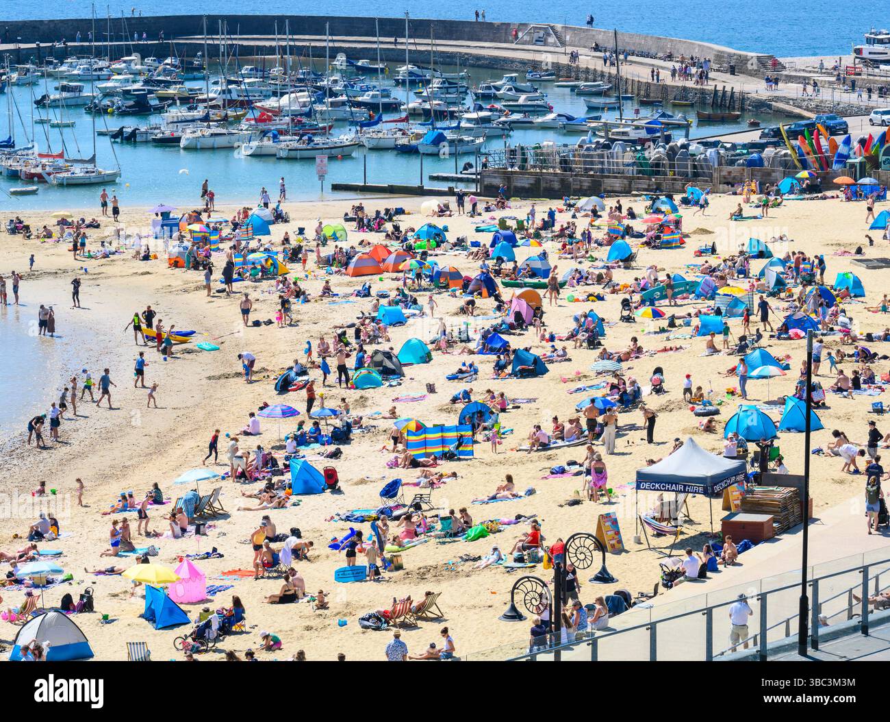Lyme Regis, Dorset, UK. 18th May, 2025. UK Weather. Sunbathers flock to ...
