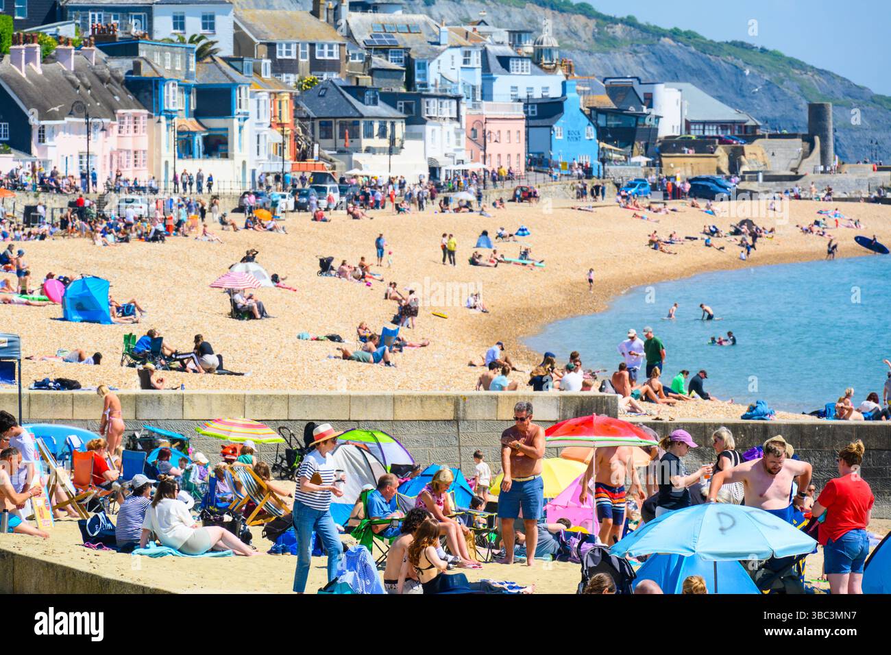 Lyme Regis, Dorset, UK. 18th May, 2025. UK Weather. Sunbathers flock to ...