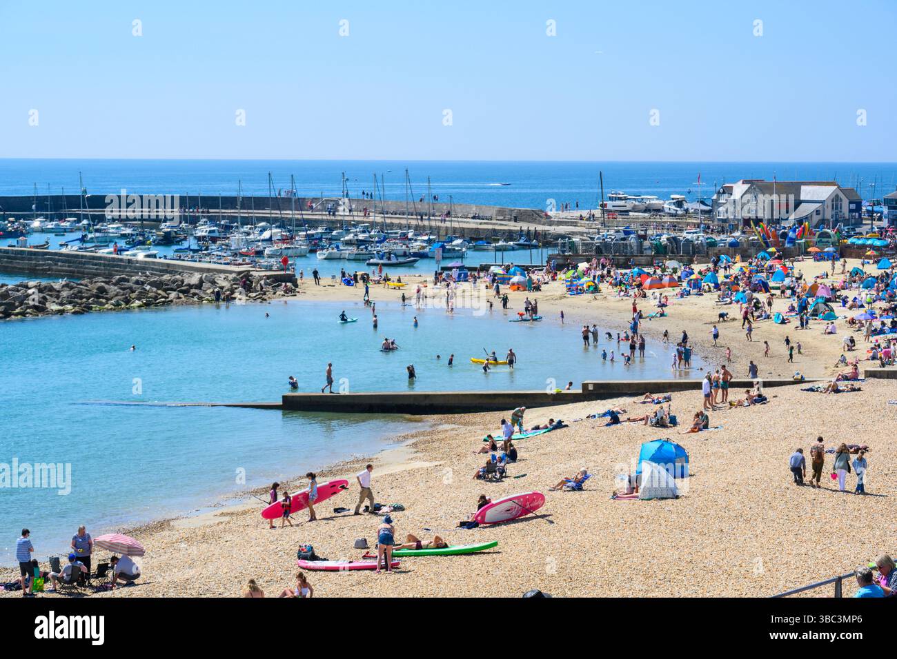 Lyme Regis, Dorset, UK. 18th May, 2025. UK Weather. Sunbathers flock to ...