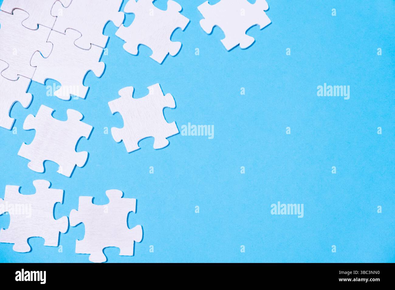 Blue background with white puzzle pieces scattered across it. The ...