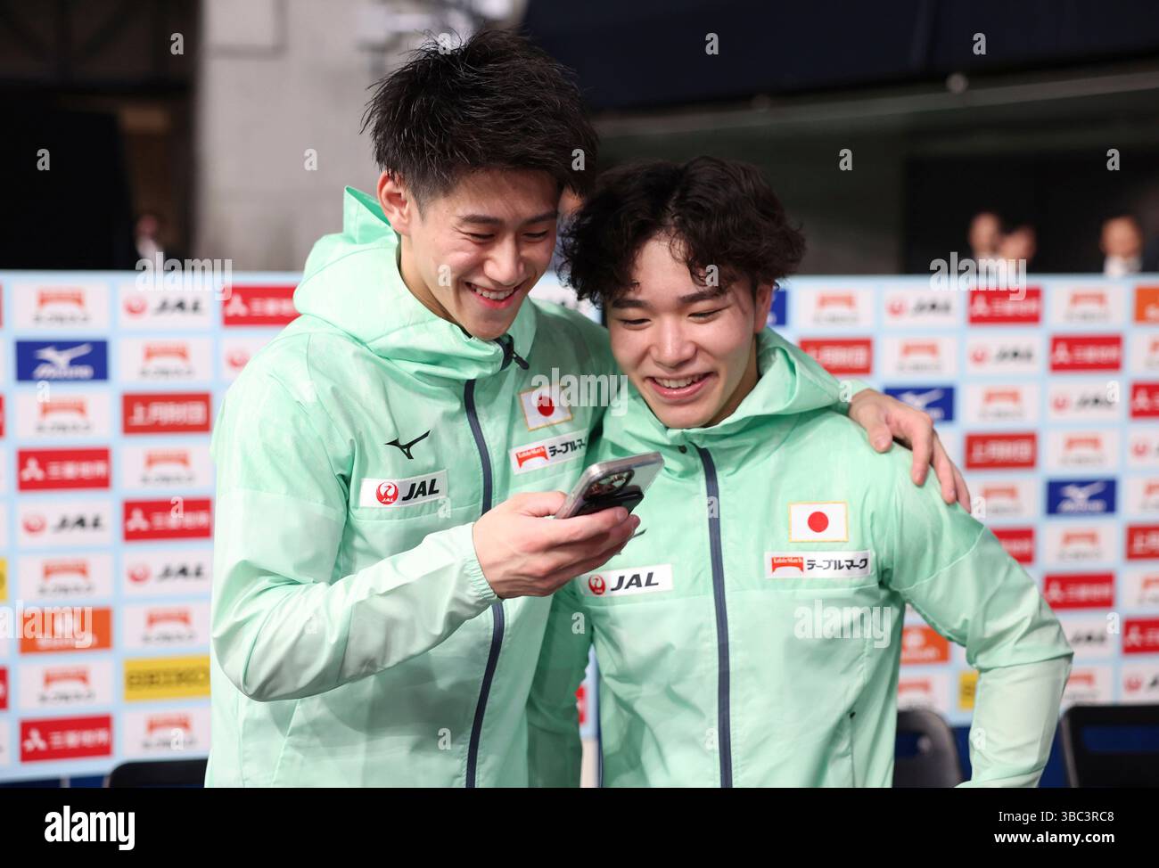 Shinnosuke Oka (R) and Daiki Hashimoto, of Japan, look at their selfies of commomerative photos ...