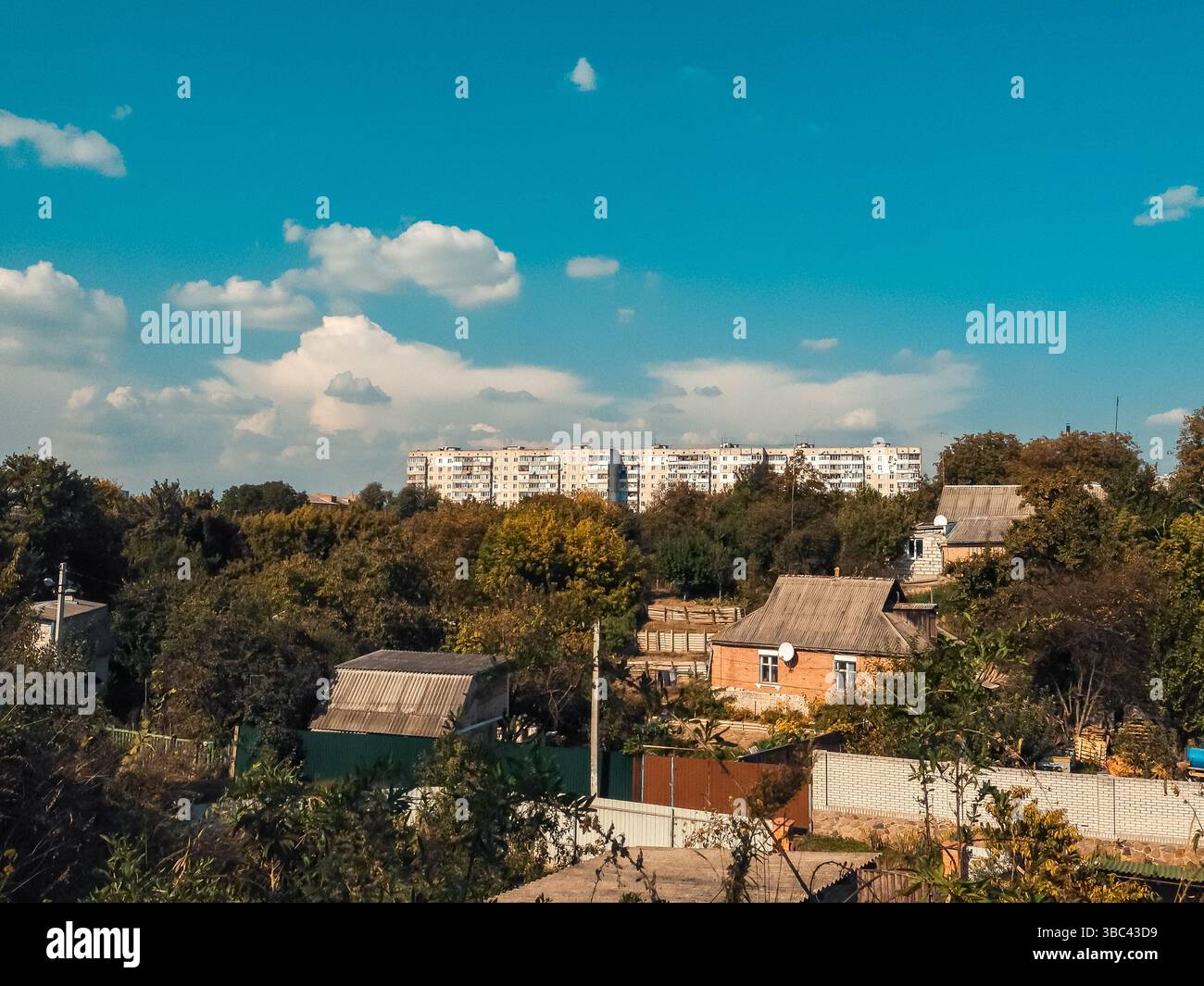 Small town with a few houses and a large building. The sky is blue and ...