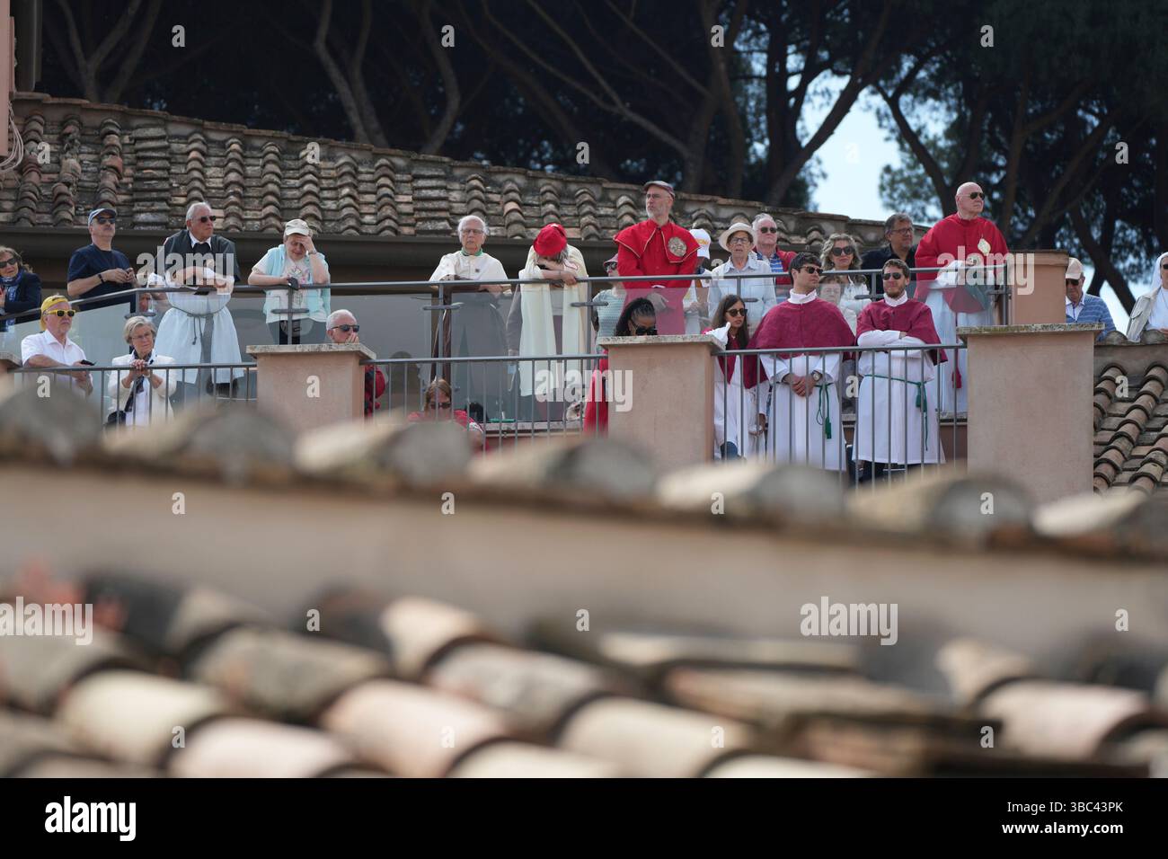 People on a roof follow Pope Leo XIV celebrating the inaugural Mass of ...