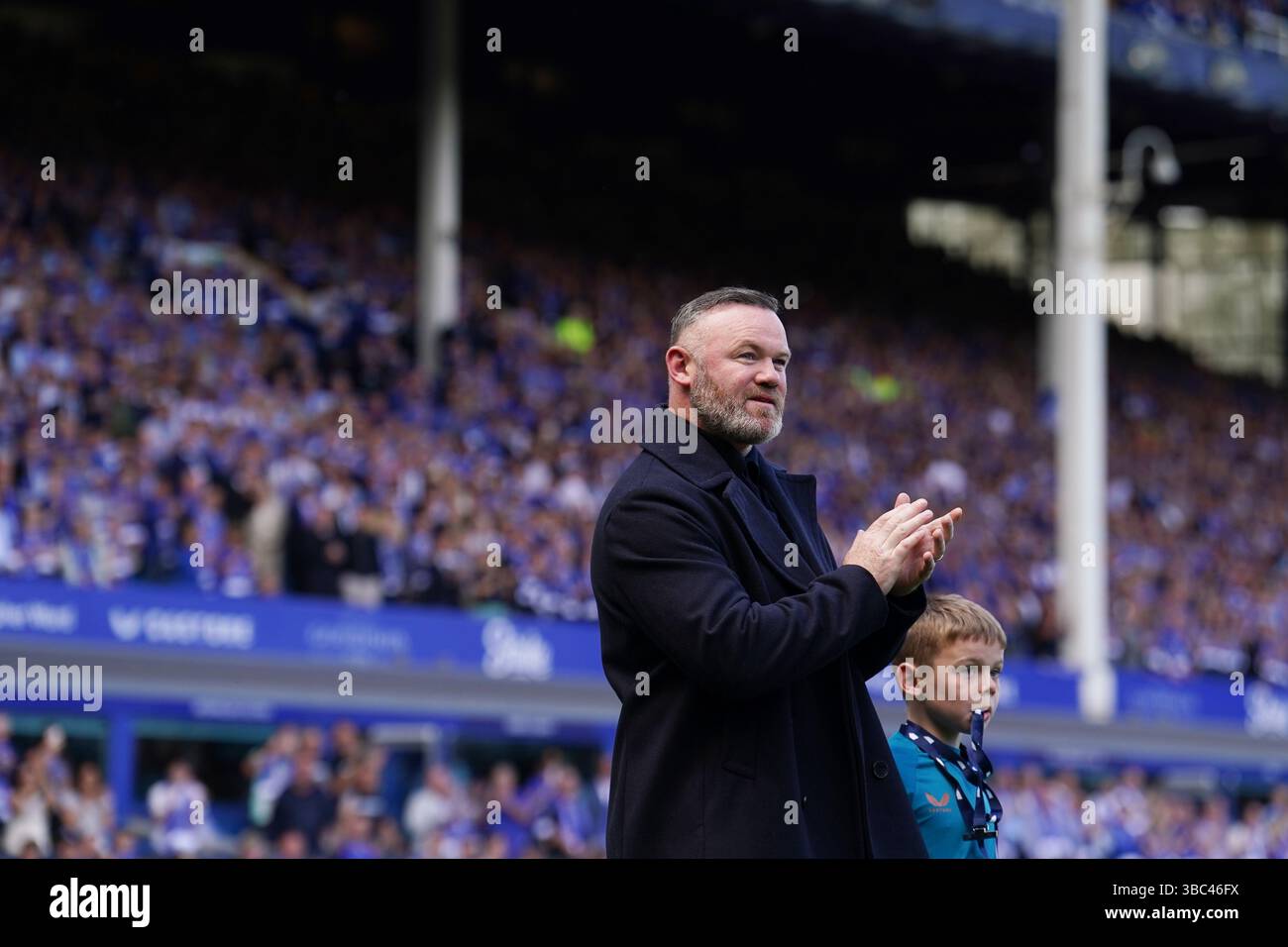 Former Everton player Wayne Rooney with his son Cass on the pitch after ...