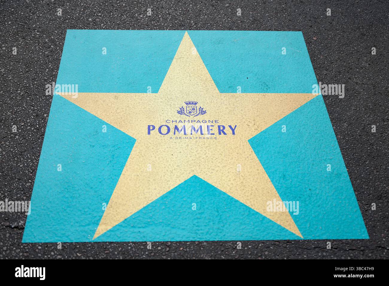 Germany Berlin May 11, 2025. Champagne Pommery Star on the Ground. The turquoise and gold star ...