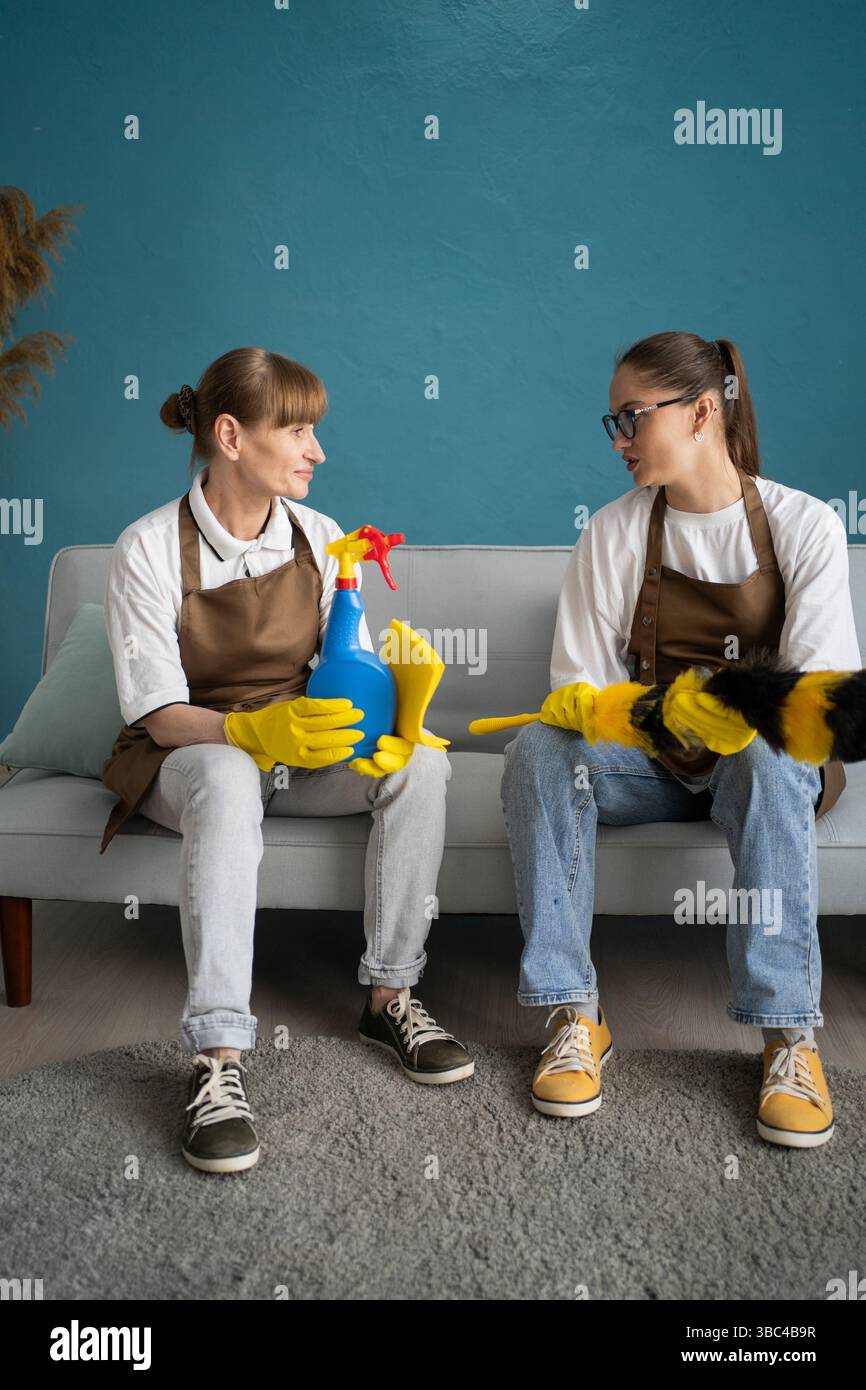 Two Female Janitors Sitting on Sofa Resting and Talking After Cleaning ...