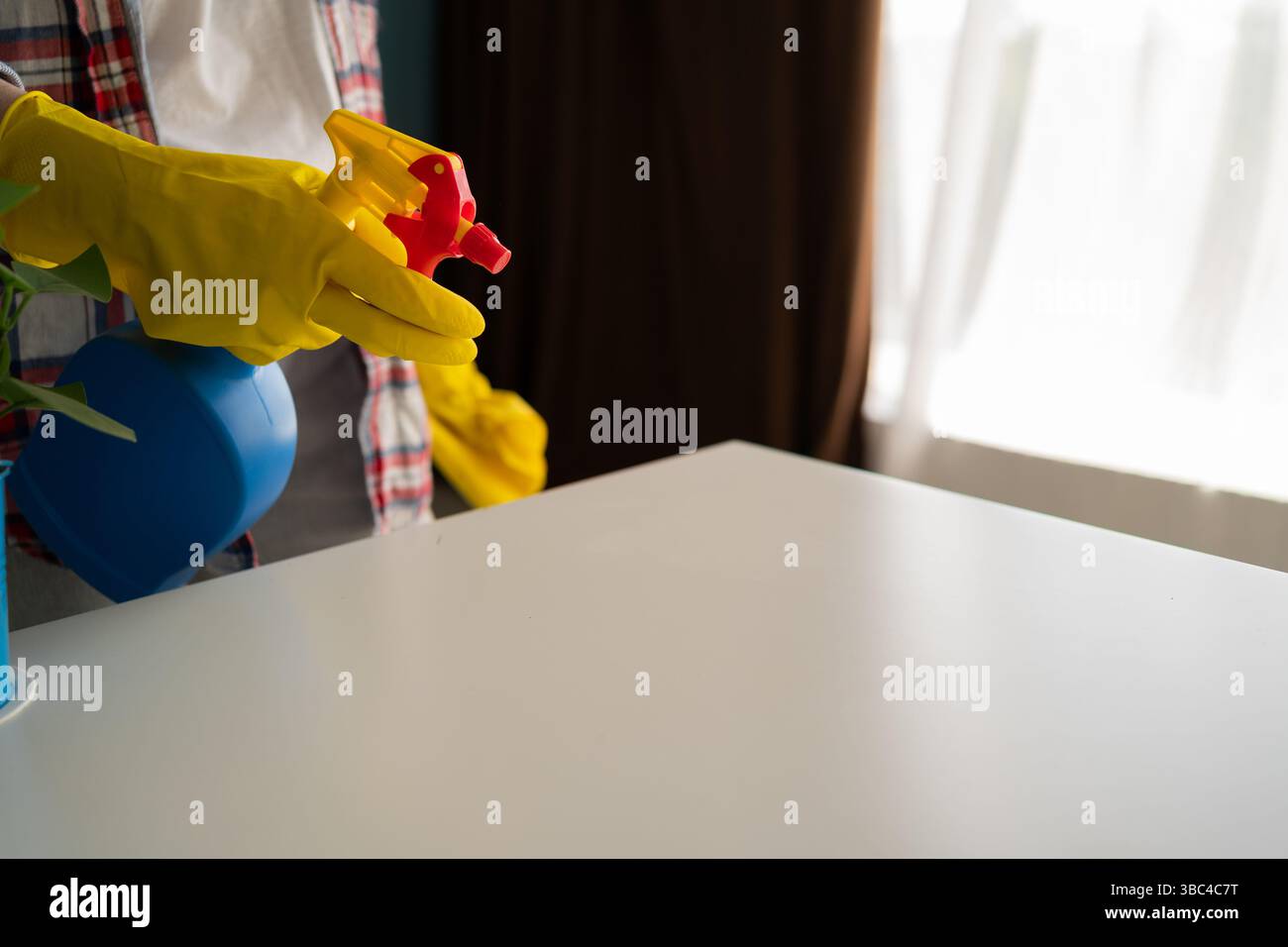 Antiseptic liquid sprayed on table surface during home cleaning process ...