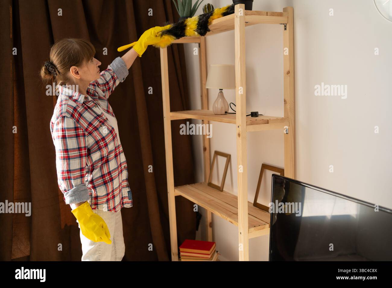 Spring cleaning concept. Housewife cleaning dust from shelf using ...