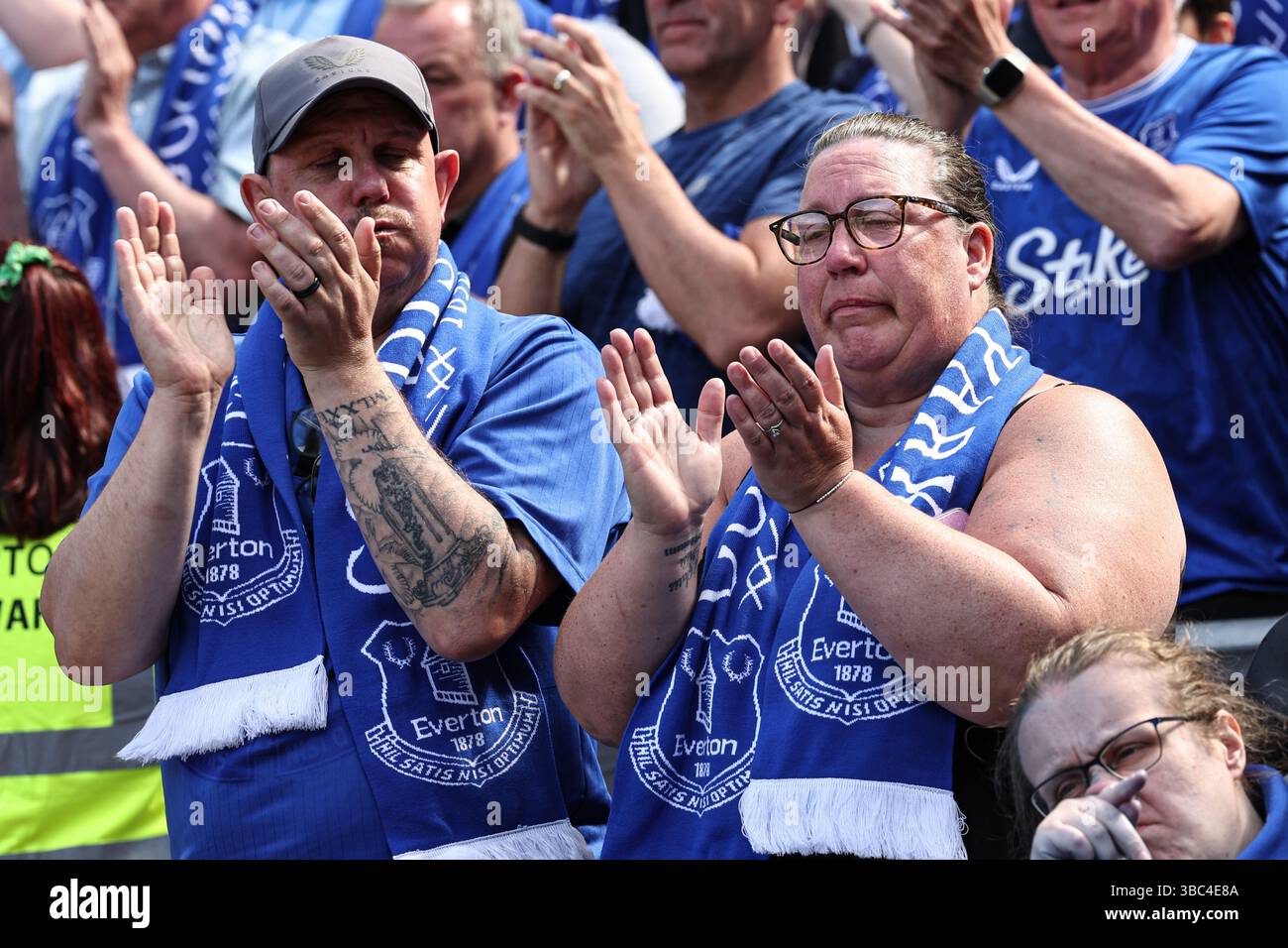 Two Everton fans embrace with a sad look but also celebrating the ...