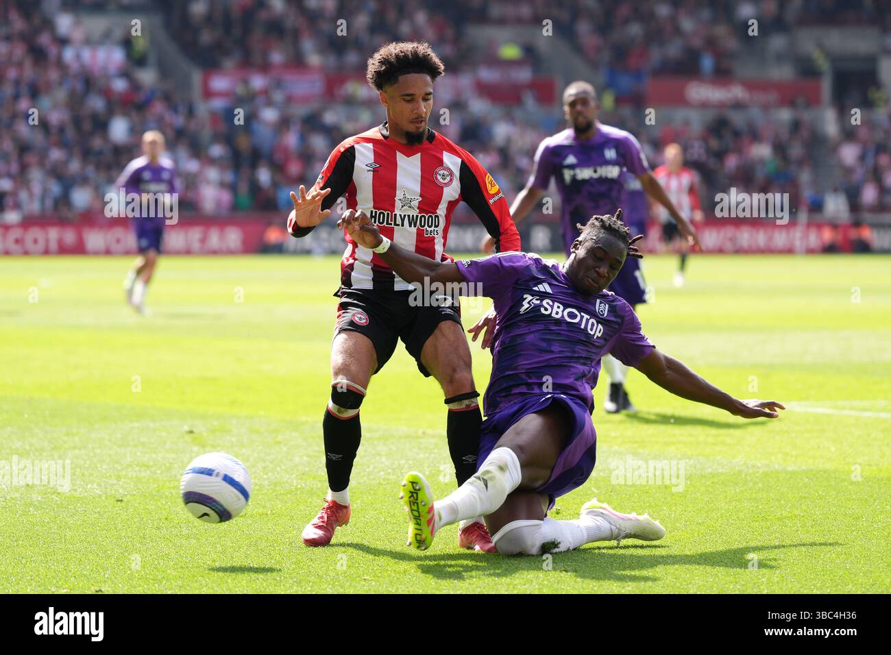 Brentford's Kevin Schade (left) is tackled by Fulham's Calvin Bassey ...