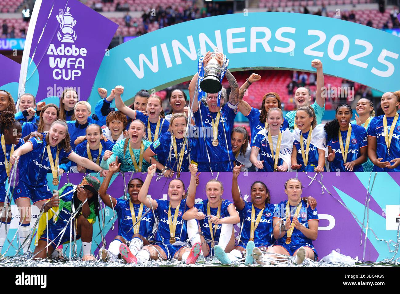 Chelsea's Millie Bright (centre) lifts the FA Cup trophy with team ...