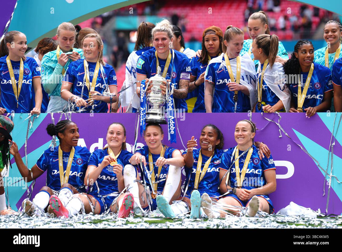 Chelsea's Millie Bright (centre) holds the FA Cup trophy with team ...