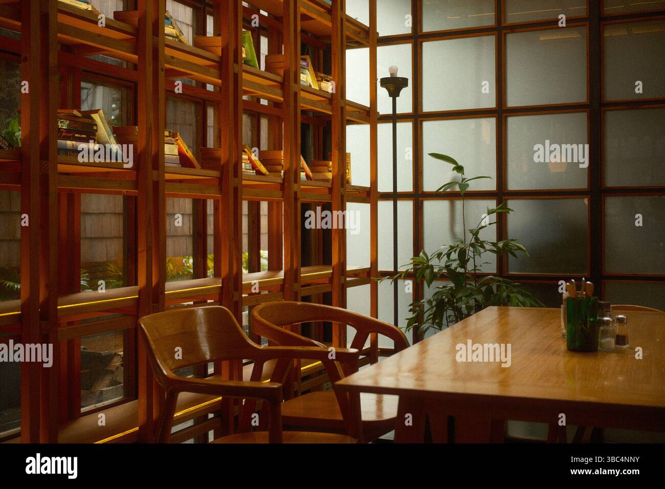 Cozy Reading Corner with wooden furniture, bookshelves, and warm natural lighting in a library ...