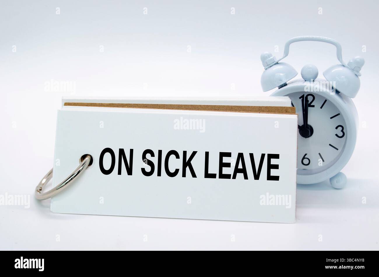 One Sick Leave text on white notepad with alarm clock on white ...