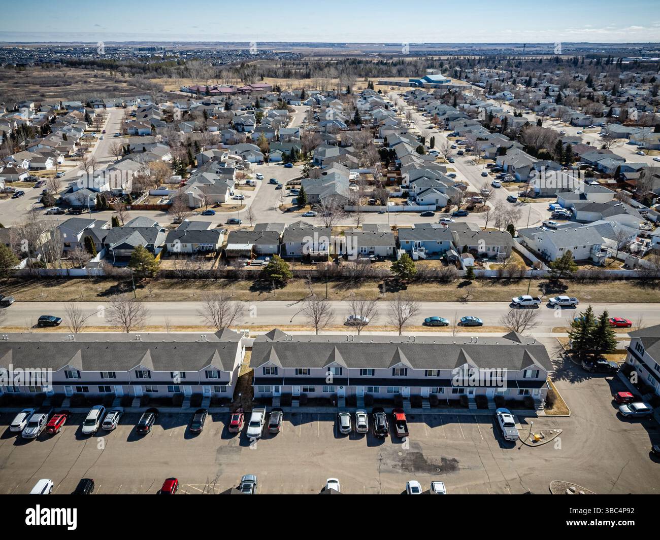 Residential area with many houses and cars parked in a lot. The houses ...