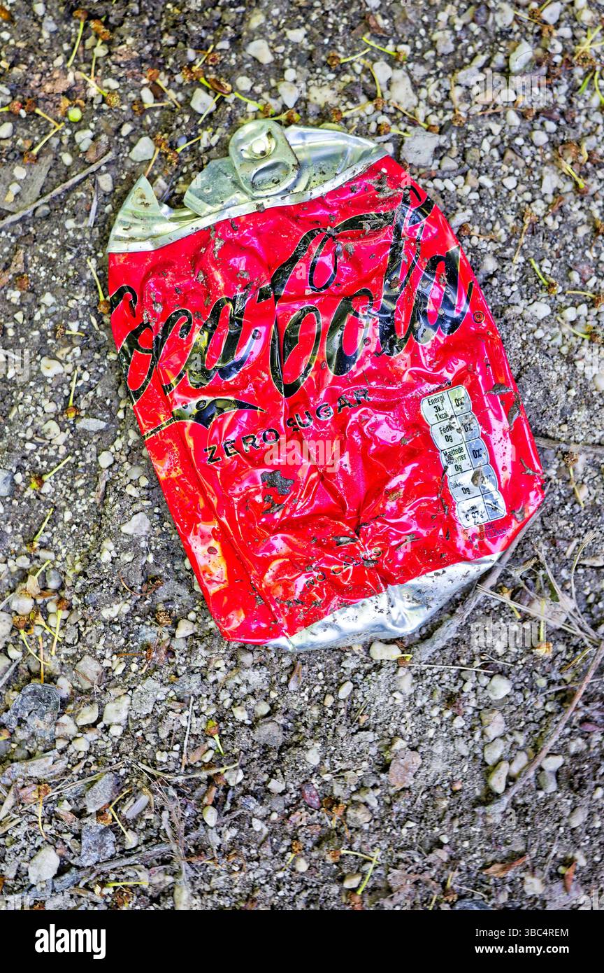 Müll. Die leere flachgetretene Coca-Cola Dose liegt am Boden. Feldwies ...