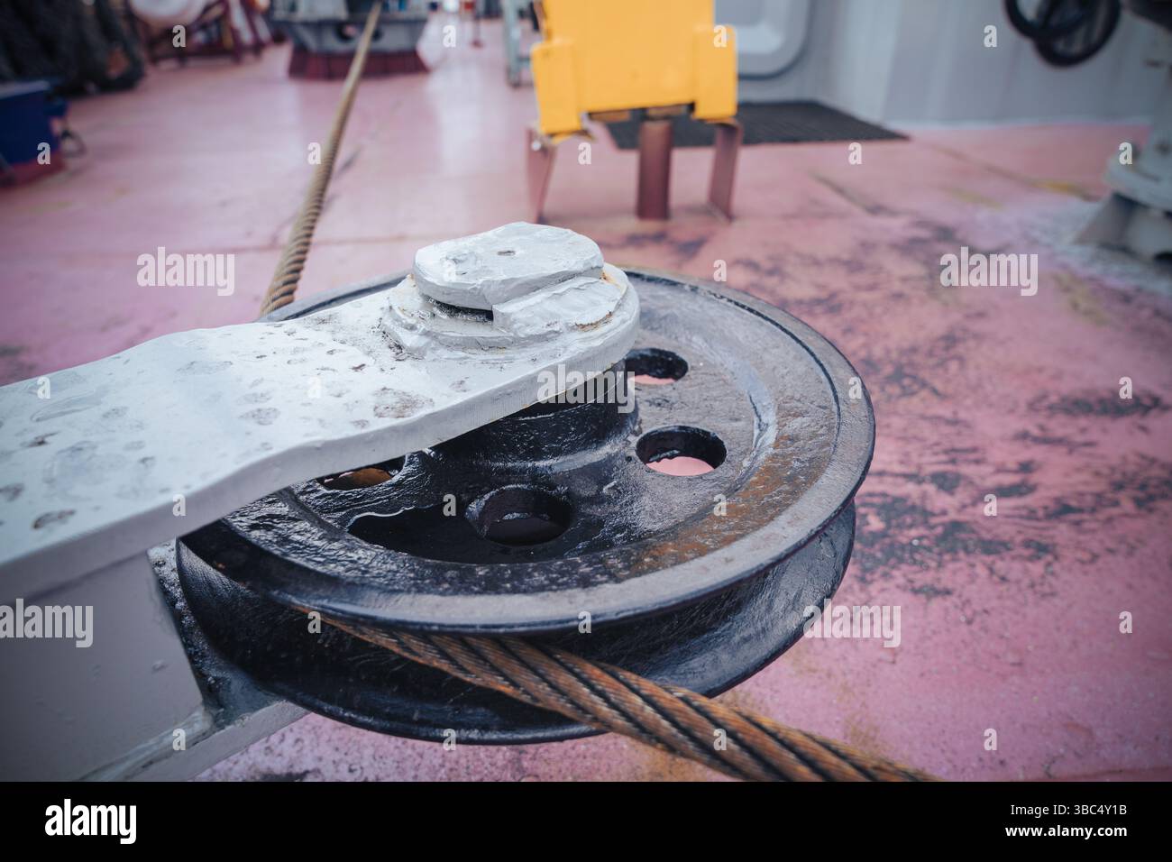 Observing a robust pulley system affixed to the deck of a large vessel ...