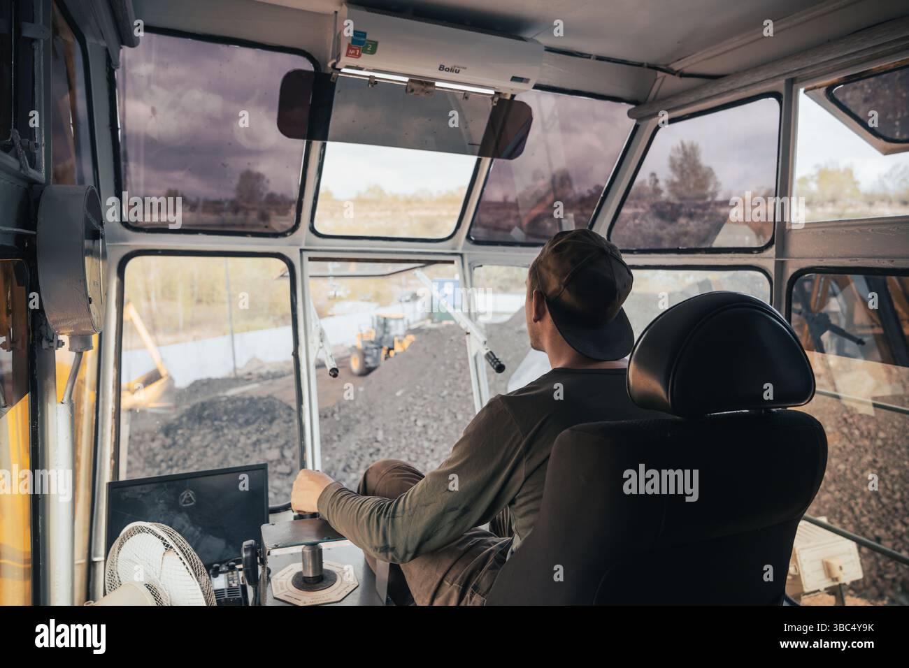 A crane operator controls heavy machinery at a coal loading dock ...
