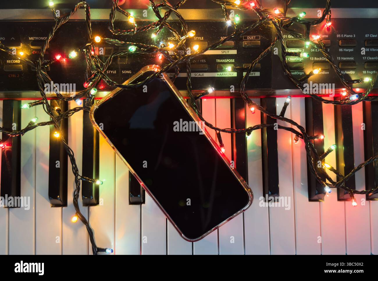 Chritmas balls and gift boxes on classical piano keyboard, smartphone ...